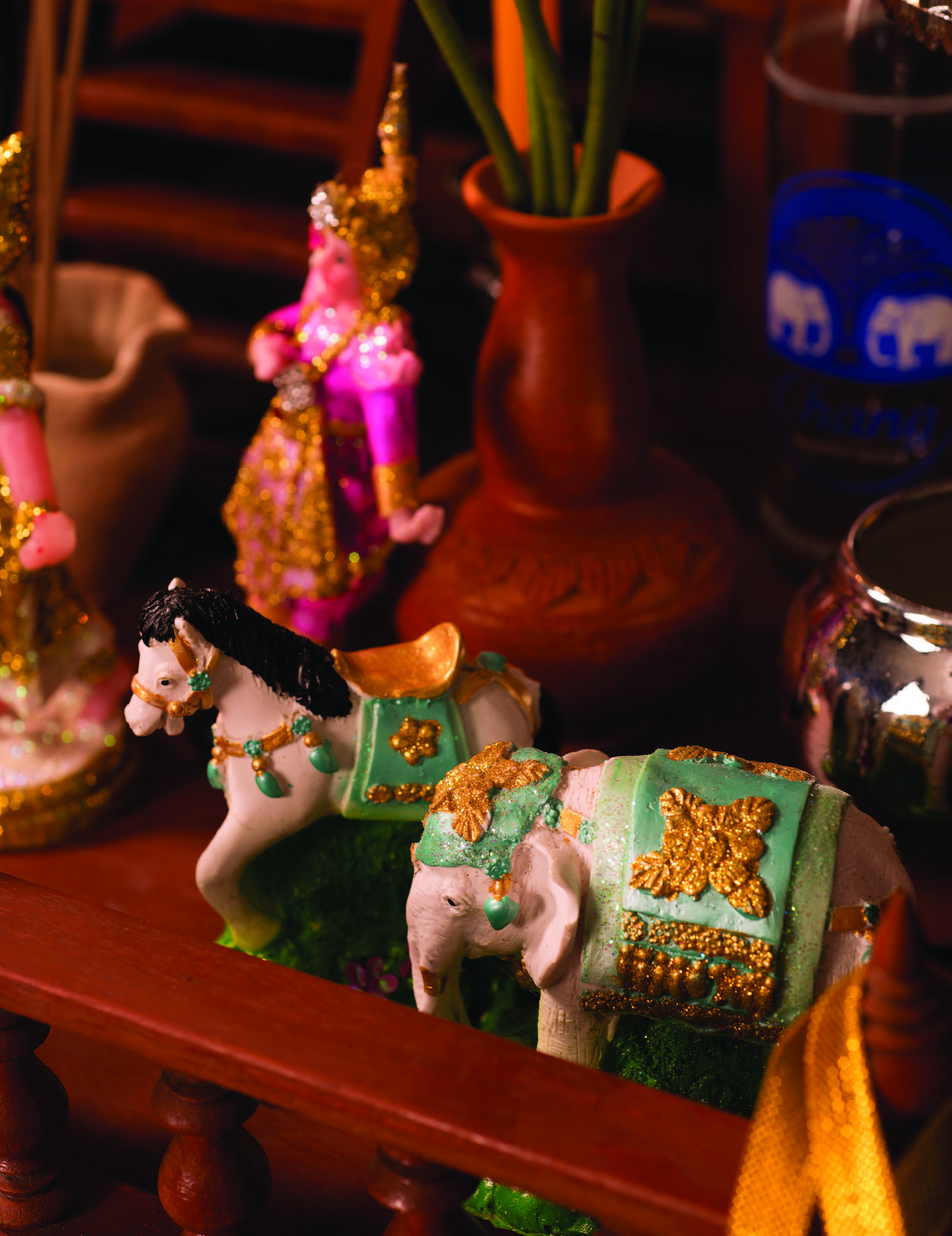 Detail of spirit house offerings. A horse and elephant are vehicles for ...
